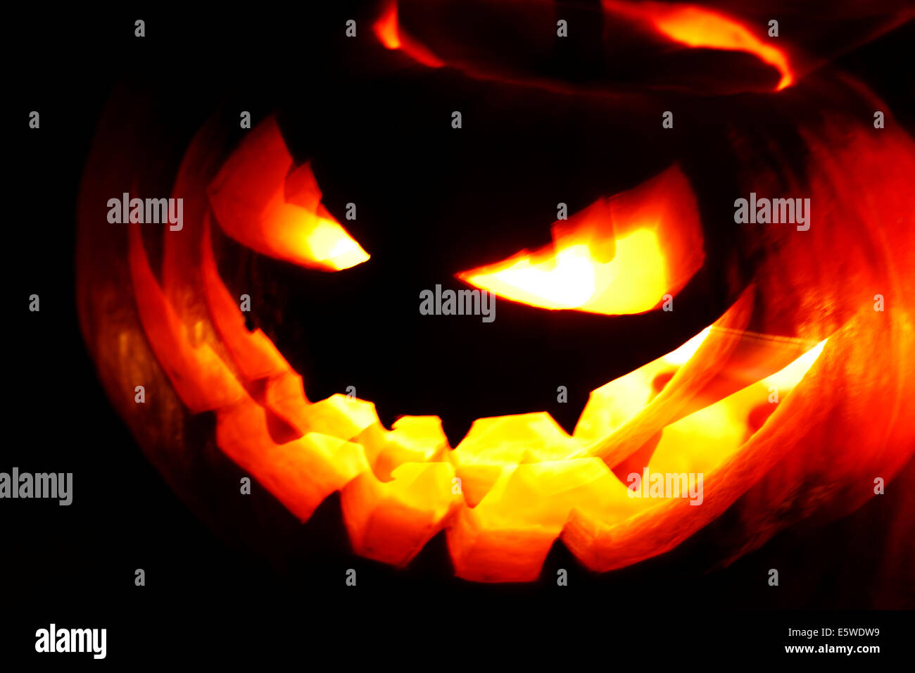 Glowing Halloween pumpkin with rays of light on black background Stock ...