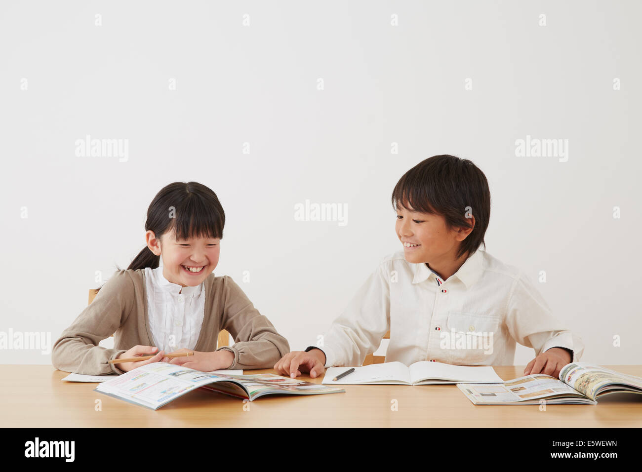 Kids doing their homework on wooden desk Stock Photo - Alamy
