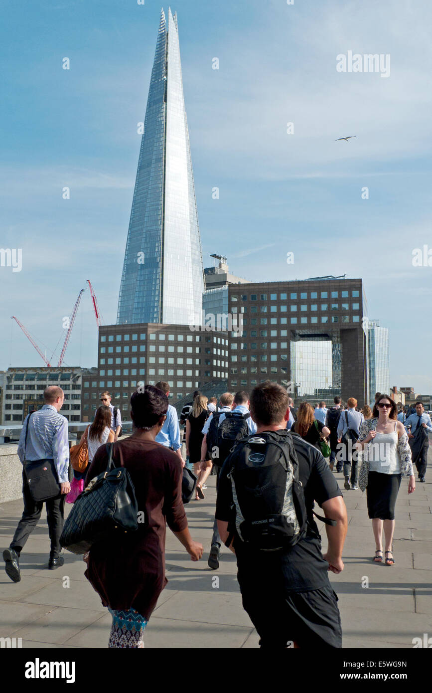 City of London office workers walking across London Bridge after work ...