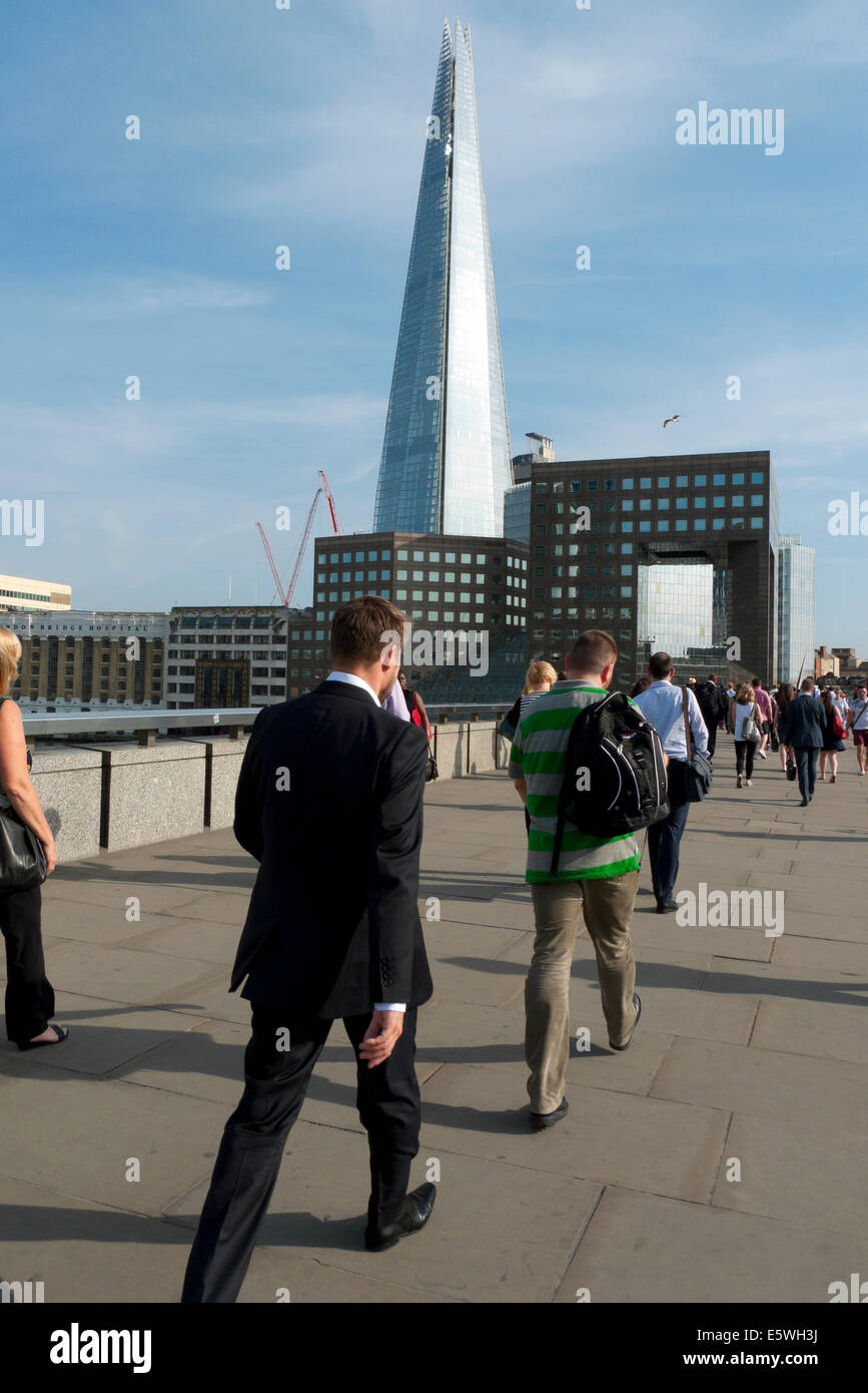 City of London office workers walking across London Bridge after work ...