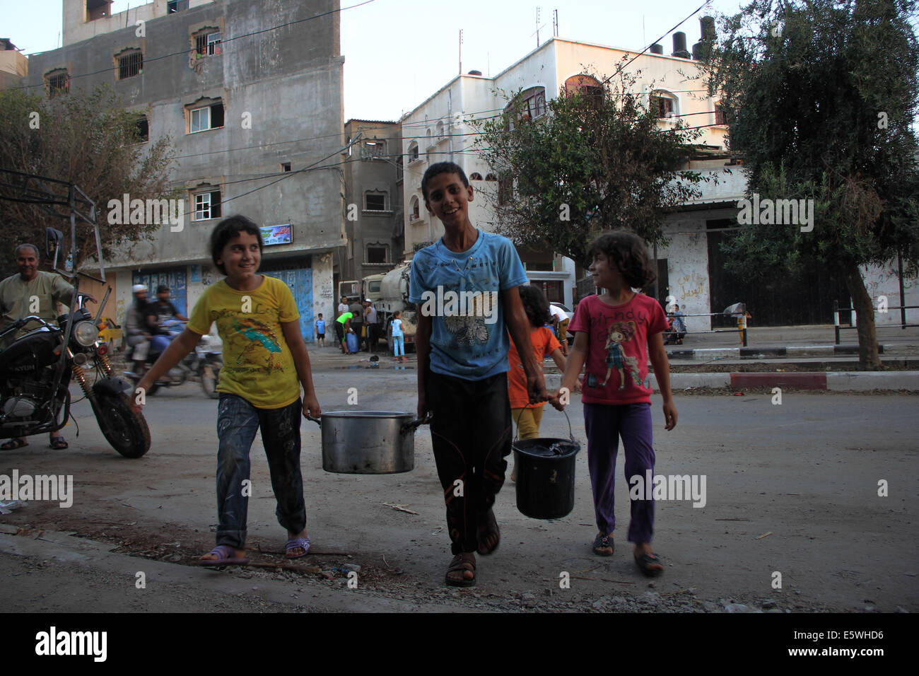 Gaza. 7th Aug, 2014. Palestinian children carrying a bucket of water ...