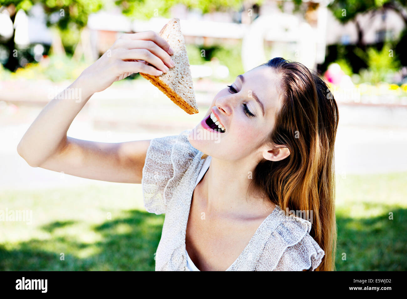 Woman eating a sandwich Stock Photo - Alamy