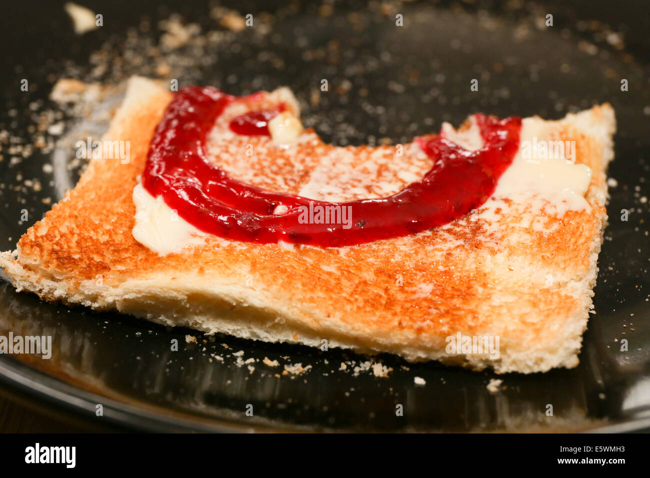 Half eaten toast with strawberry jam Stock Photo - Alamy