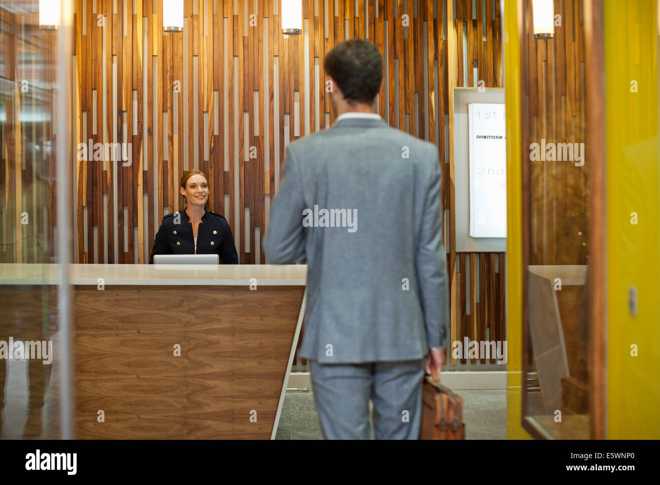 Businessman arriving at office reception Stock Photo - Alamy