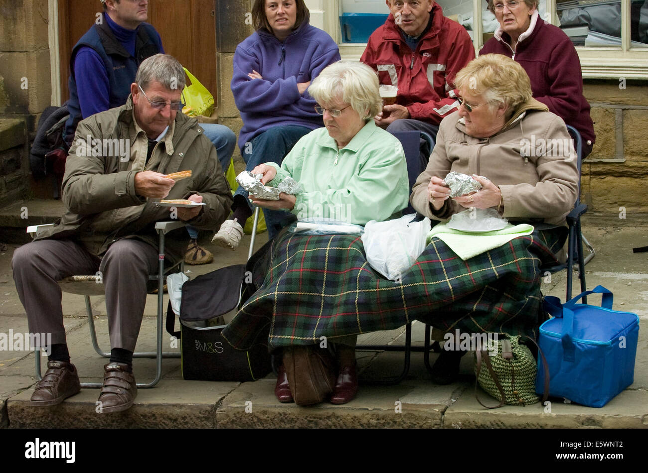 People sit on deck chairs and watch the Brass Band play at the Oldham ...