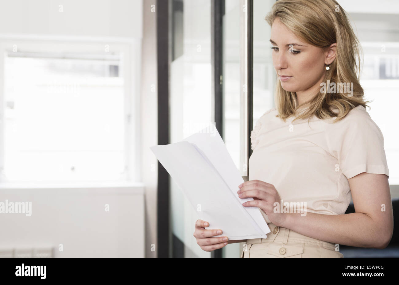Young businesswoman checking paperwork Stock Photo - Alamy