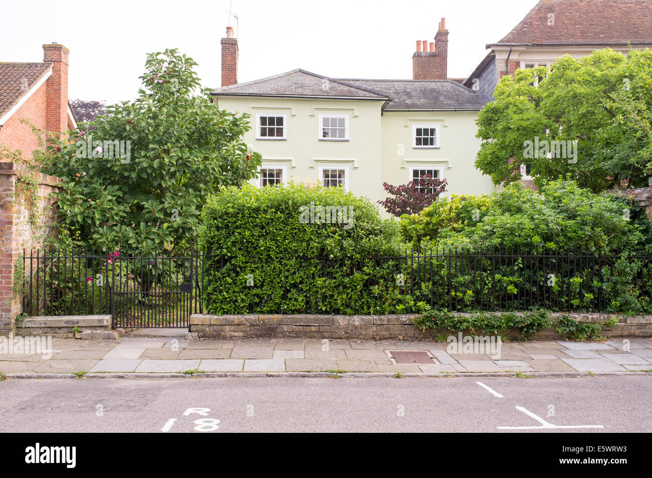 House behind green trees and hedge UK Stock Photo - Alamy