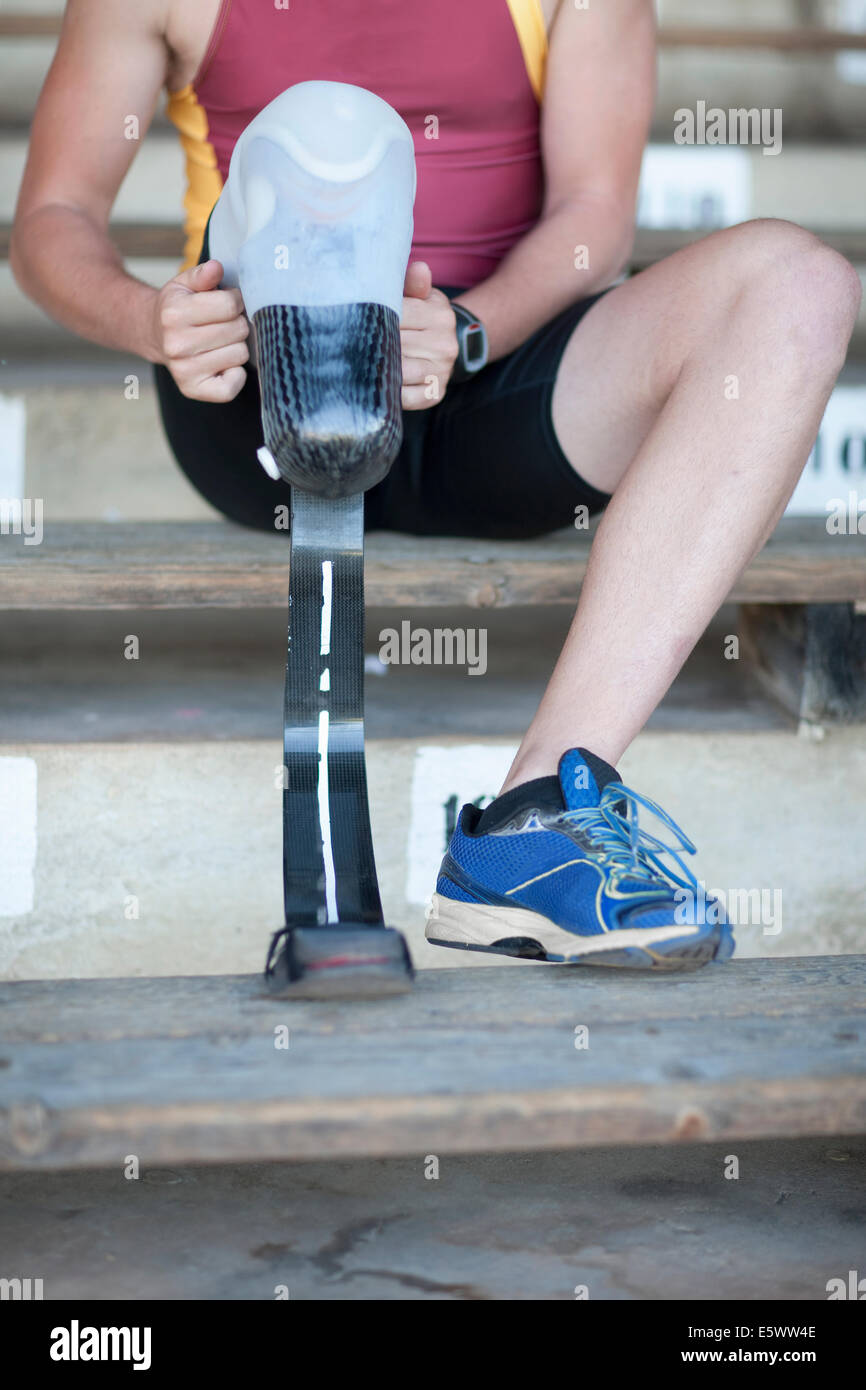 Sprinter preparing, putting on prosthetic leg Stock Photo - Alamy