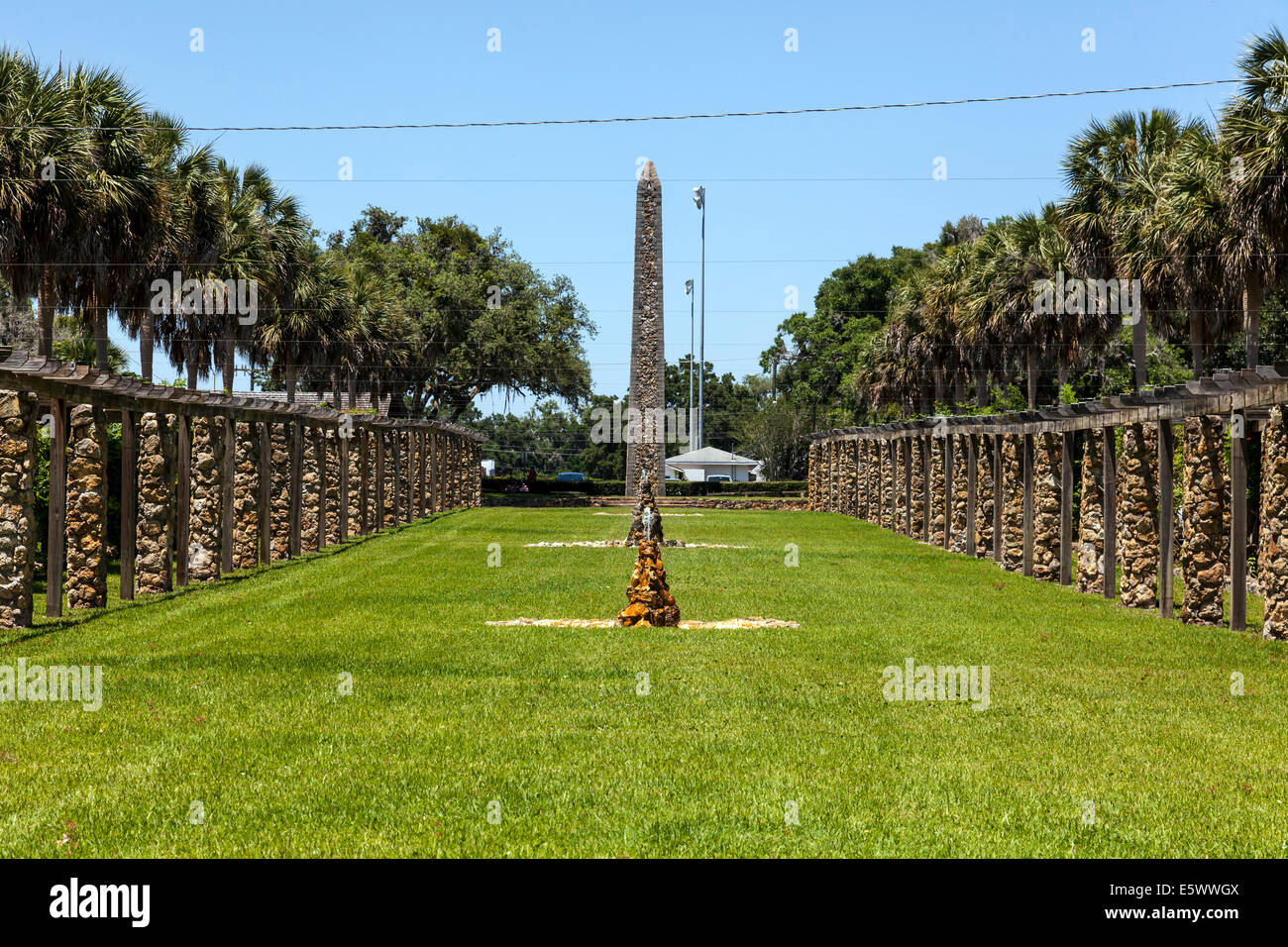 Stone columns support wood trellises flanking lawn, fountains and stone ...