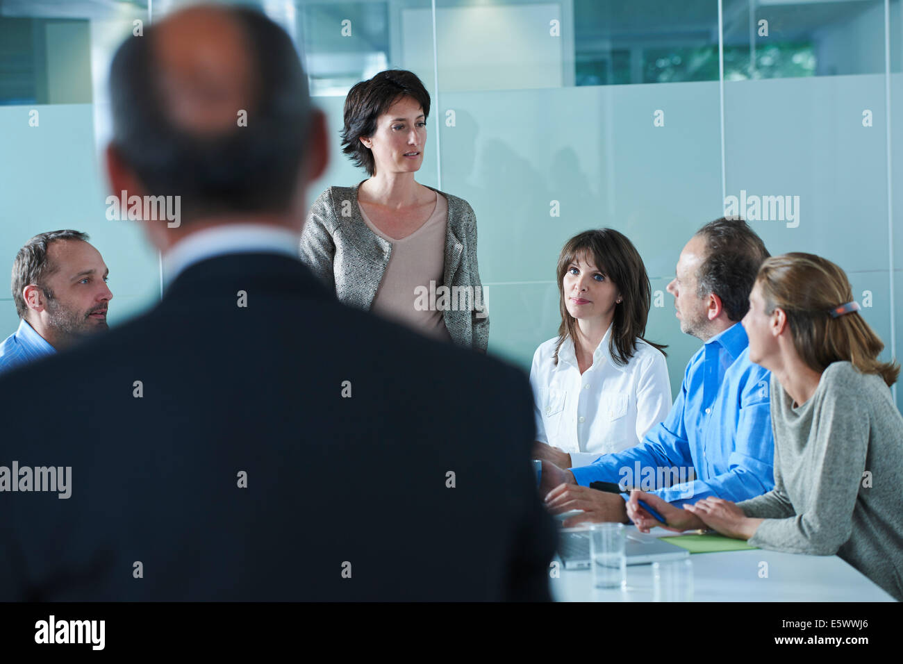 Businessmen and women arguing around boardroom table Stock Photo - Alamy