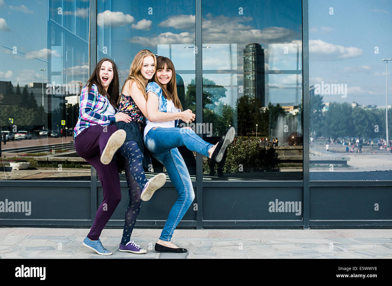 Three young women dancing on one leg in city Stock Photo - Alamy