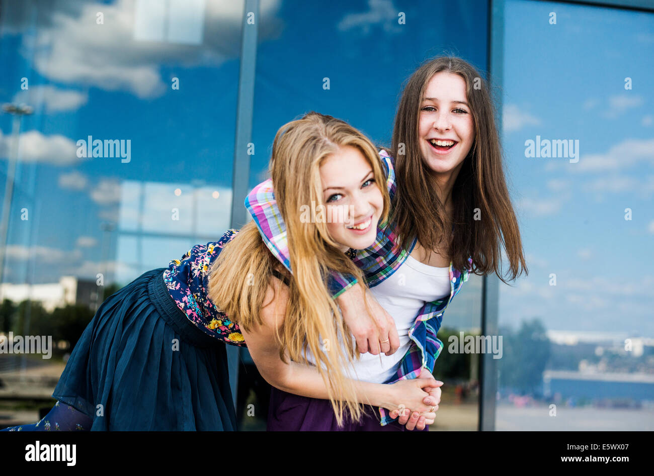 Portrait of two young women with arms around each other in city Stock ...