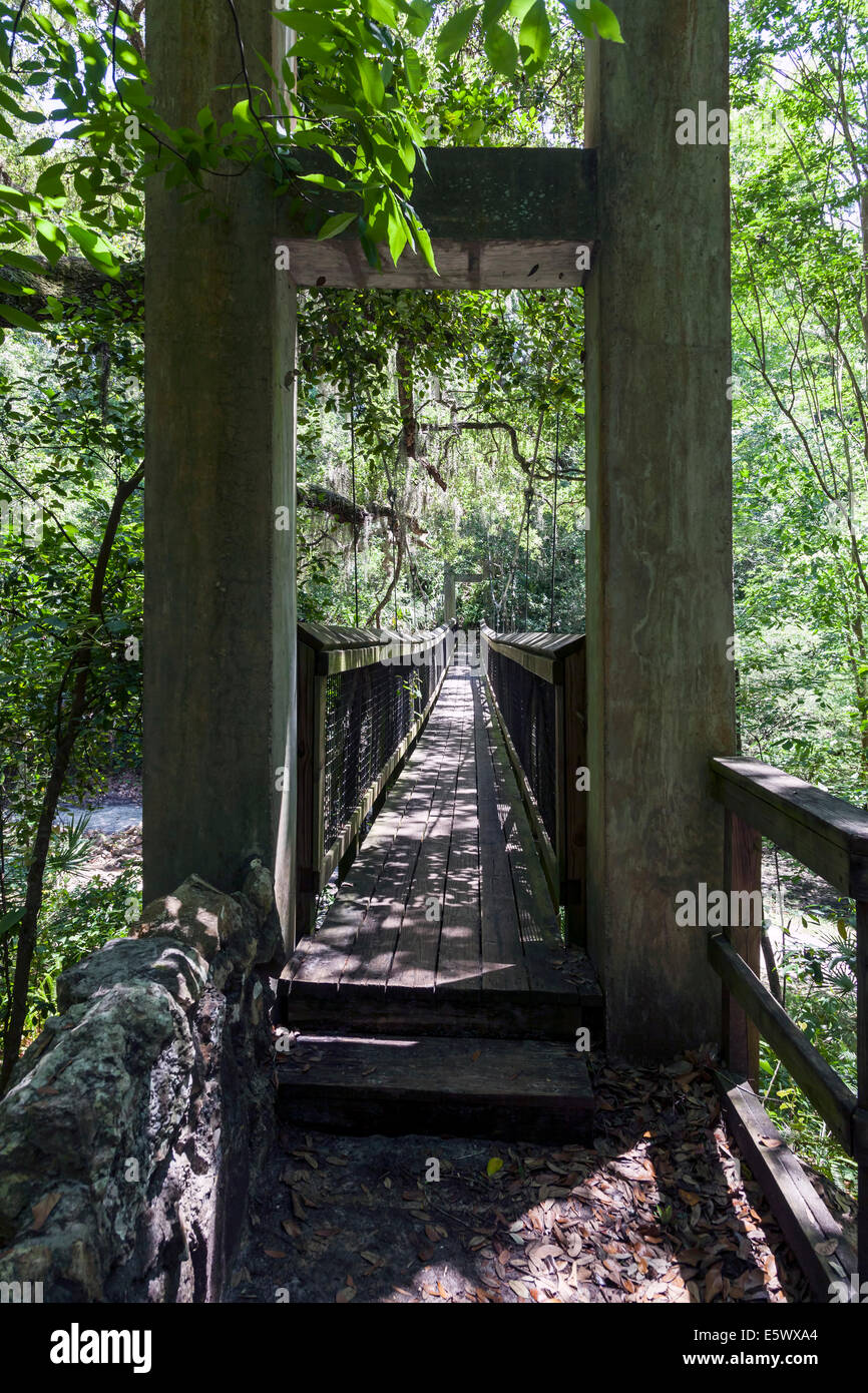 Wooden pedestrian suspension foot bridge viewed between its concrete ...