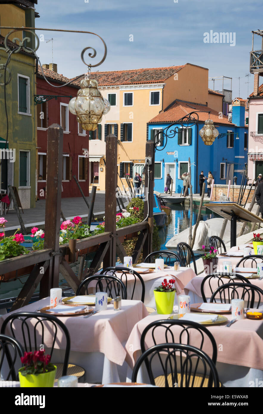 Multi colored houses and sidewalk restaurant, Burano, Venice, Veneto ...