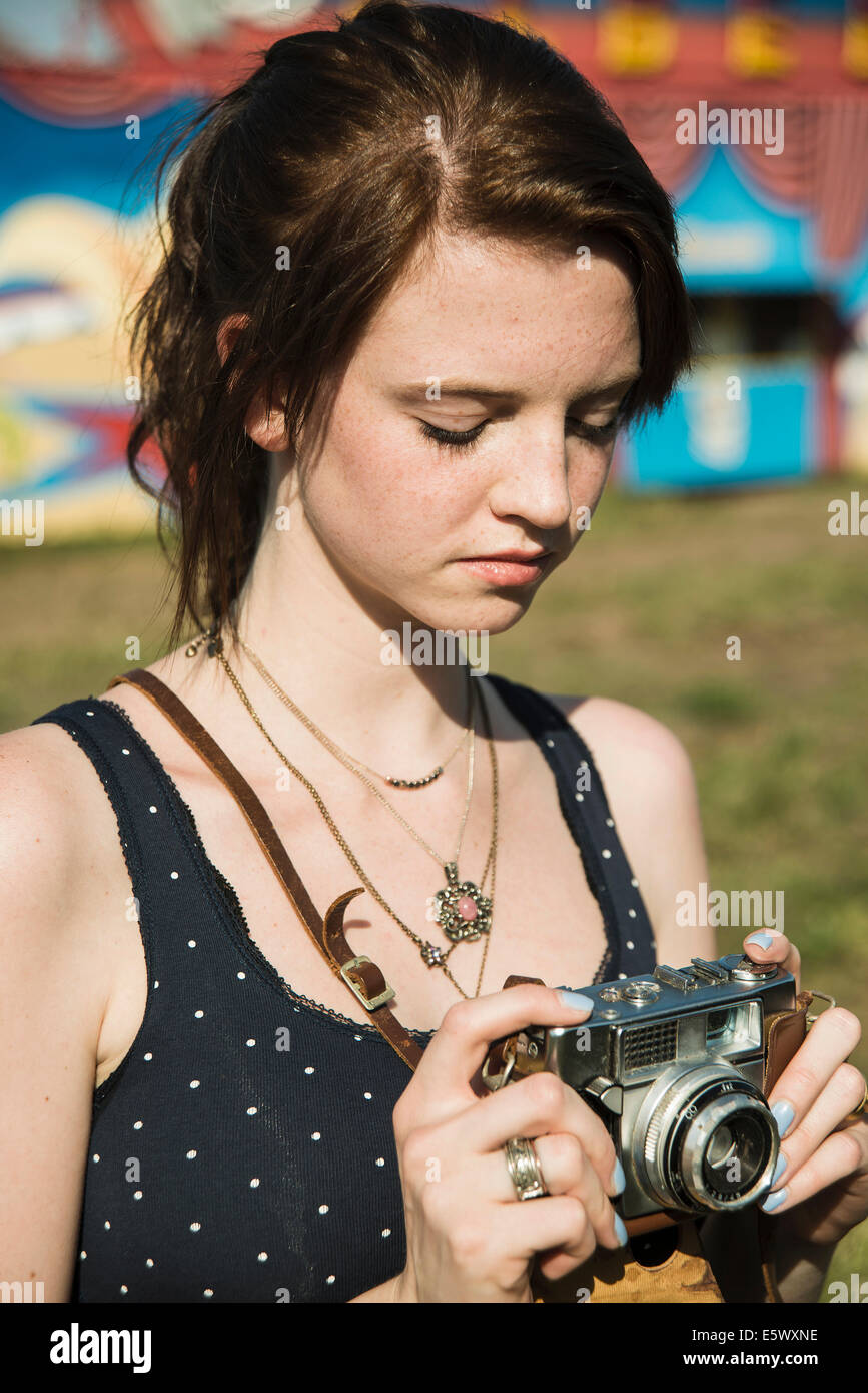 Young woman photographing on SLR camera at funfair Stock Photo - Alamy