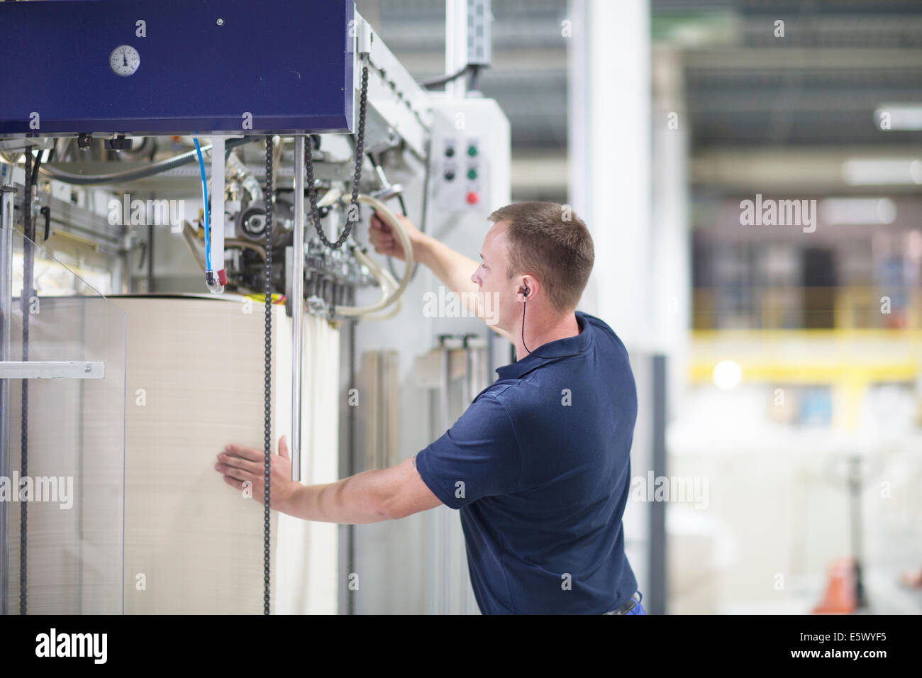 Worker using machine in paper packaging factory Stock Photo - Alamy