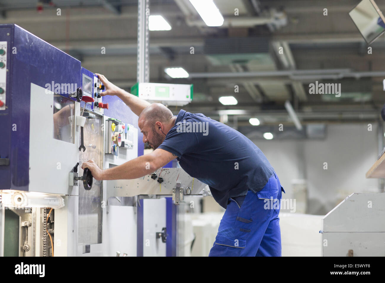 Worker using machine in paper packaging factory Stock Photo - Alamy