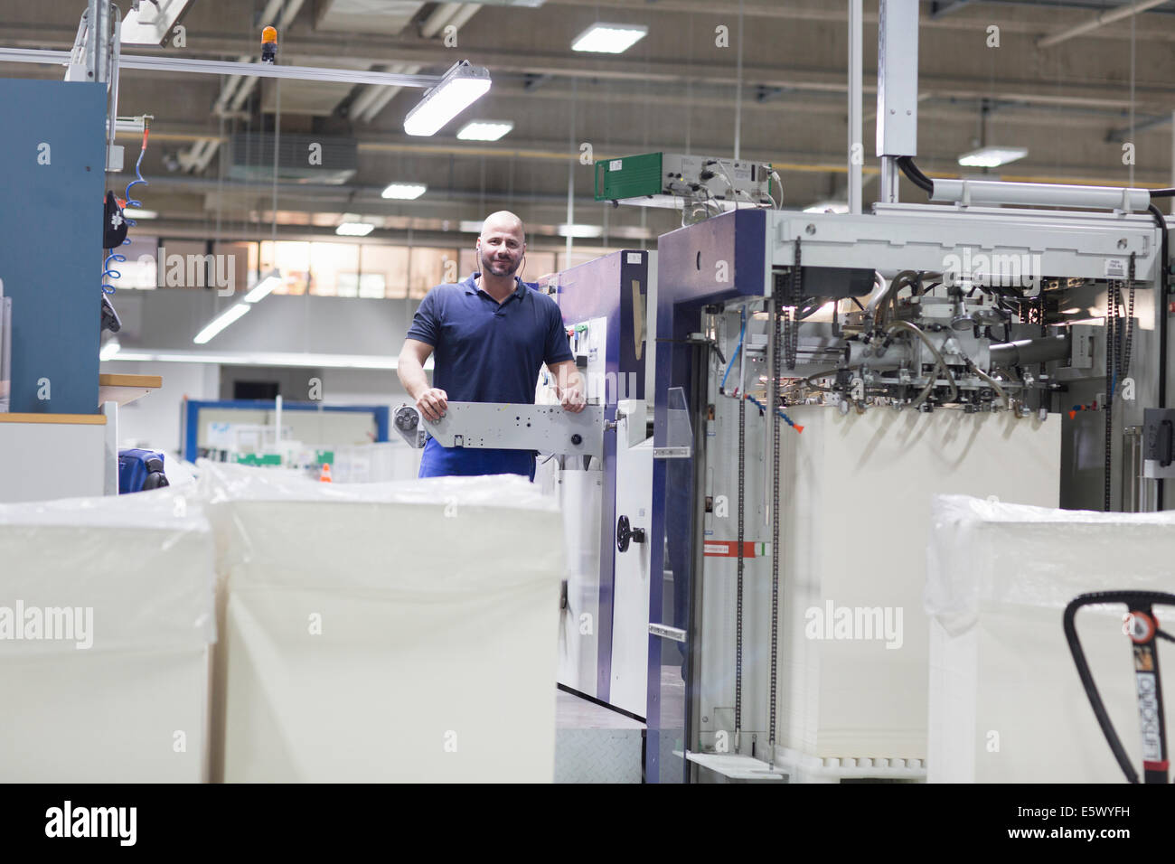 Worker using machine in paper packaging factory Stock Photo - Alamy