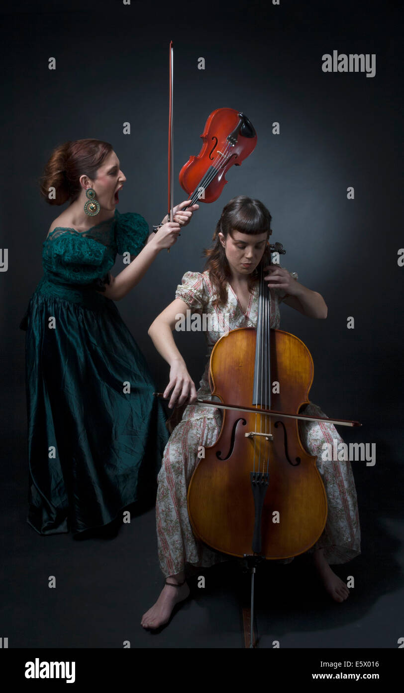 woman with violin attacking a cellist girl Stock Photo - Alamy