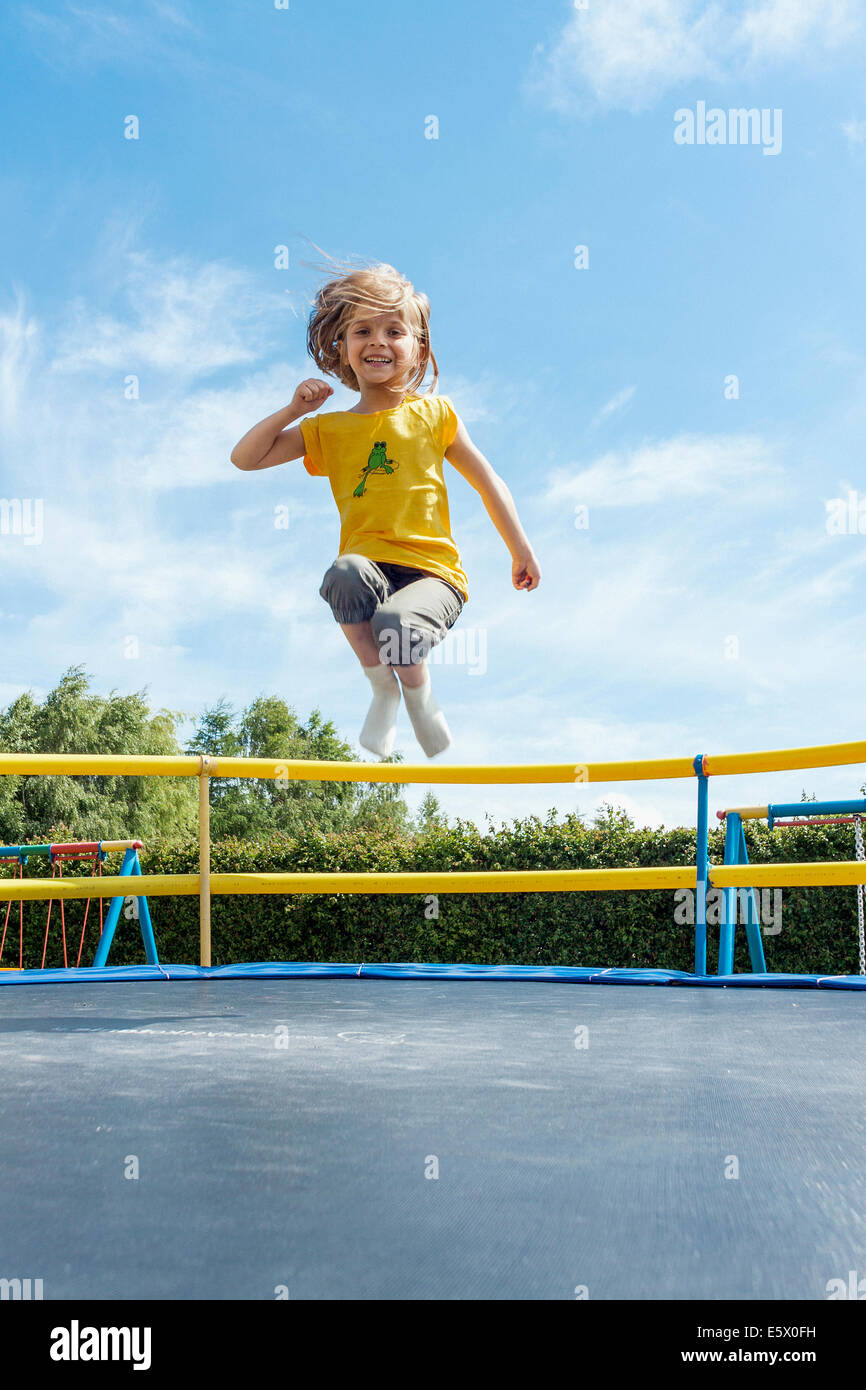 Happy girl jumping on a trampoline Stock Photo - Alamy