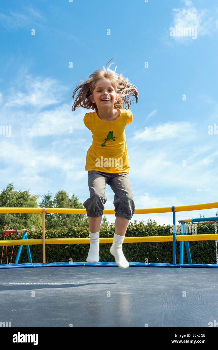 Happy girl jumping on a trampoline Stock Photo - Alamy
