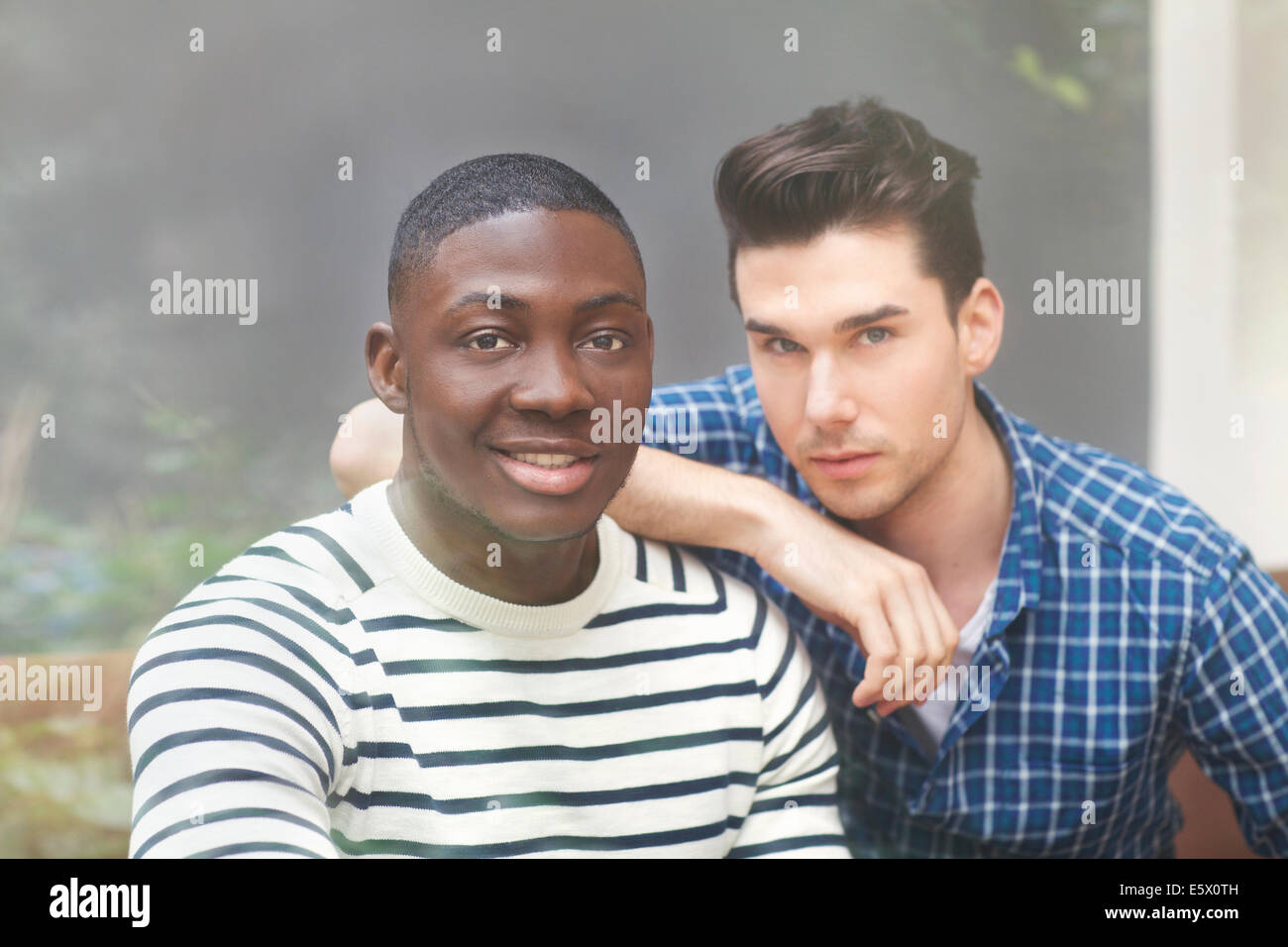 Portrait of two young men behind window Stock Photo - Alamy