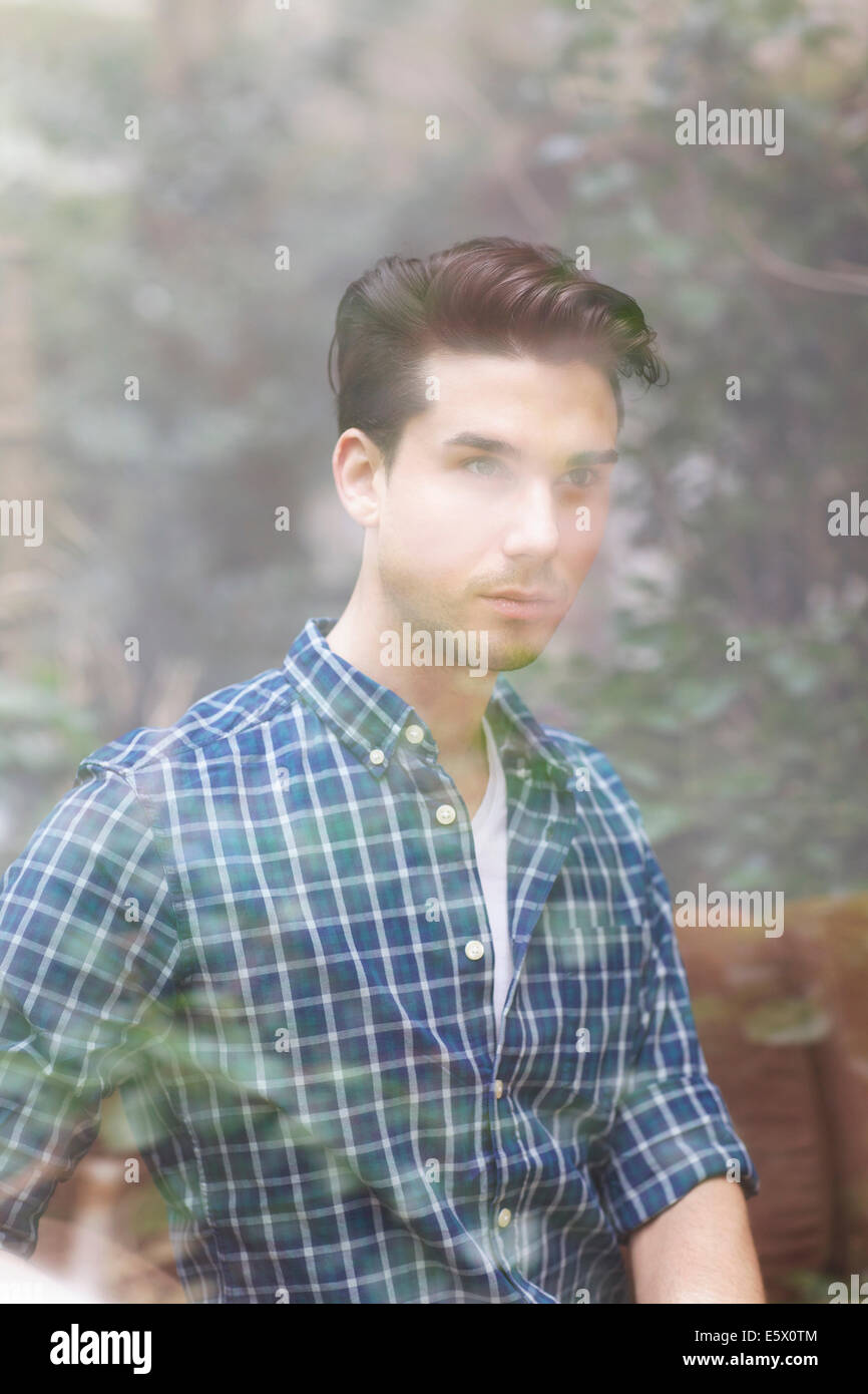Portrait of young man behind window Stock Photo - Alamy
