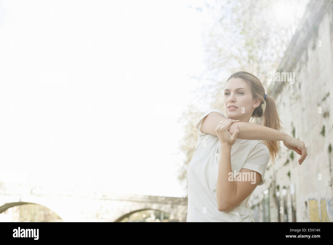 Young woman stretching arm before exercise Stock Photo - Alamy