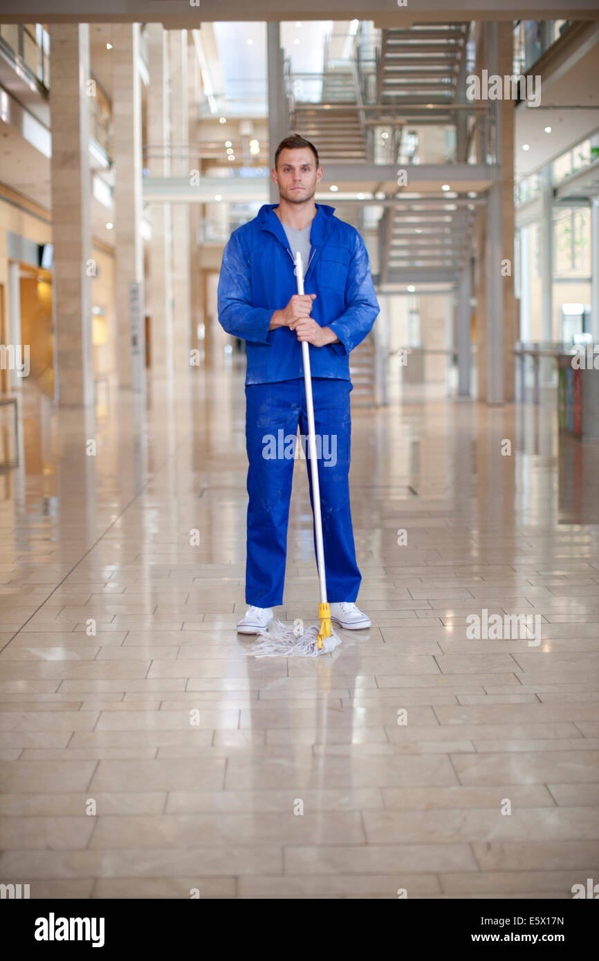 Portrait of male cleaner in office atrium Stock Photo - Alamy