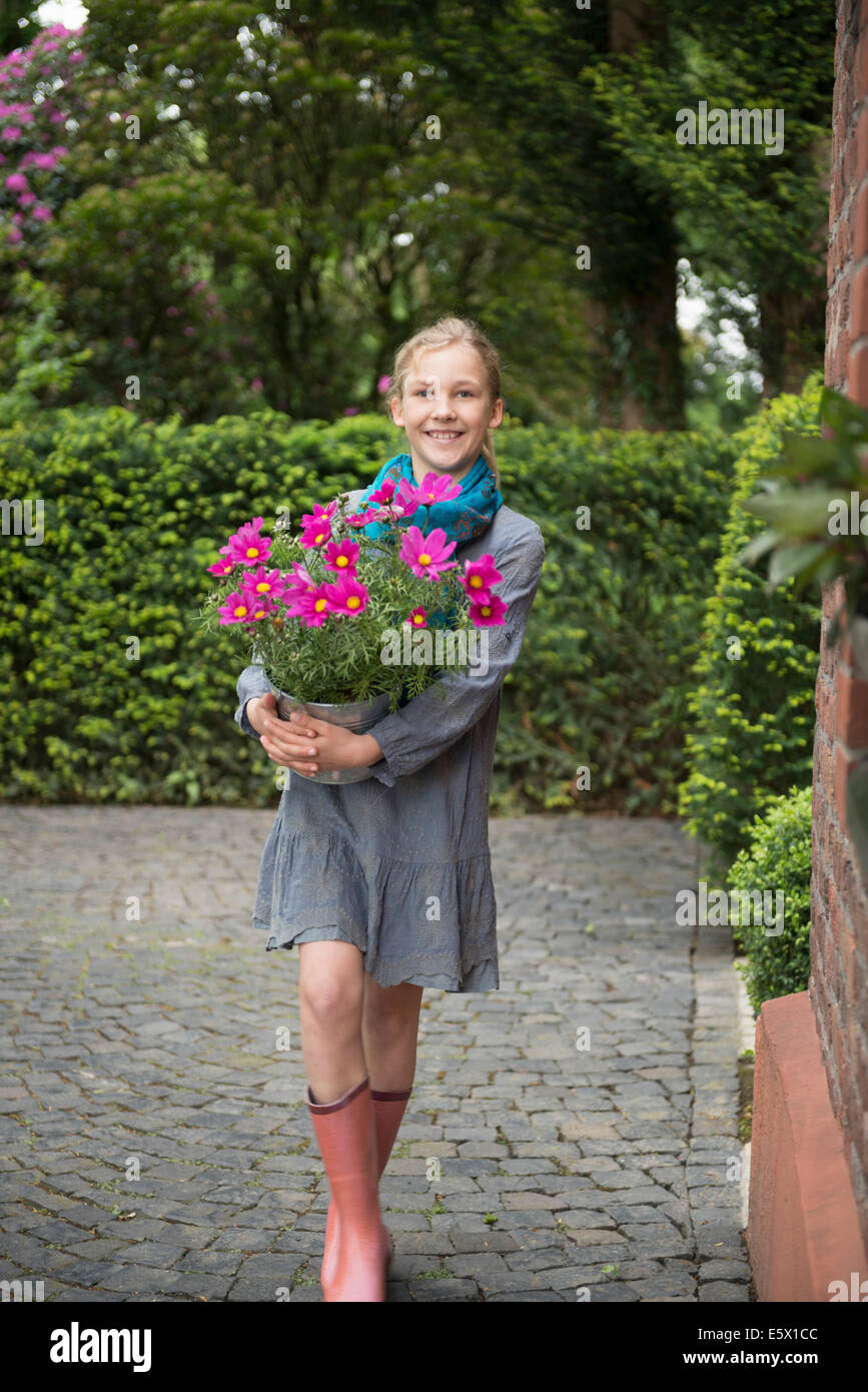 Portrait of girl with flower pot plant in garden Stock Photo - Alamy