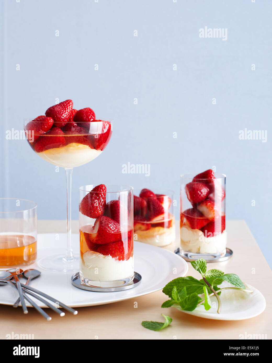 Selection of drinking glasses filled with champagne poached strawberry ...
