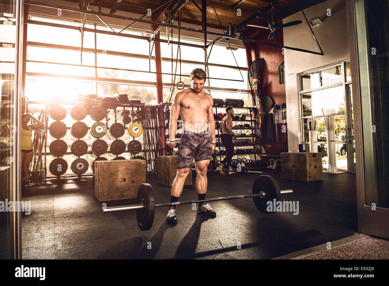 Bodybuilder looking down at barbell in gym Stock Photo - Alamy