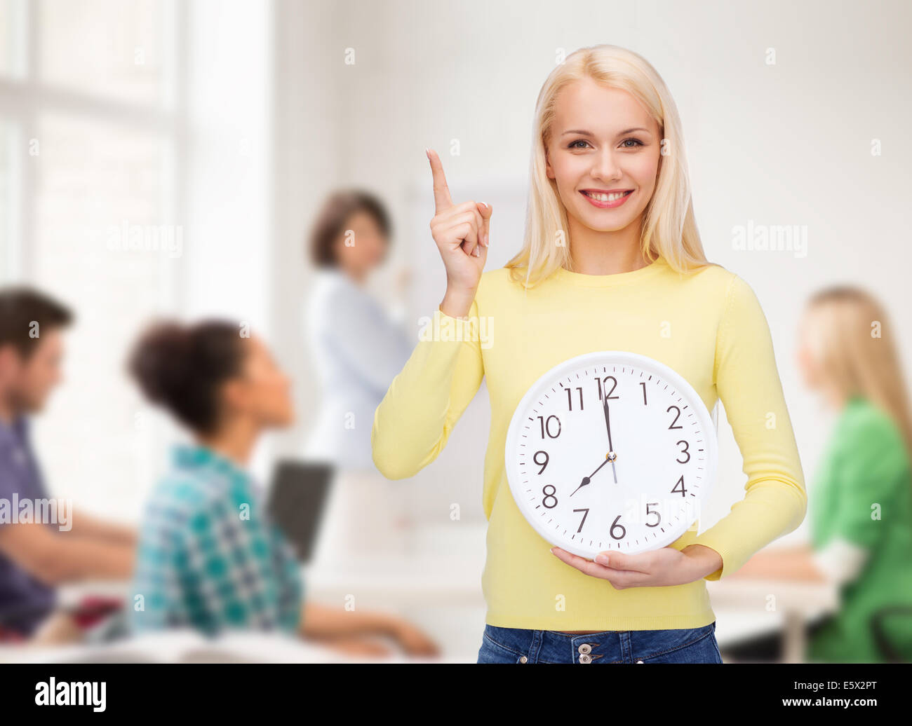student with wall clock and finger up Stock Photo - Alamy