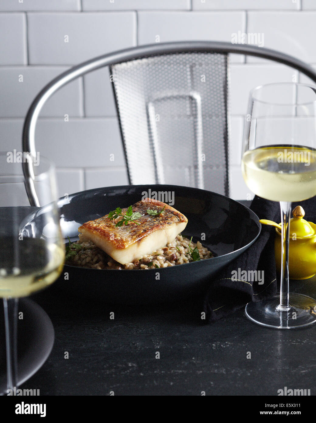 Bowl of pan fried red snapper with herb garnish on a bed of wild ...