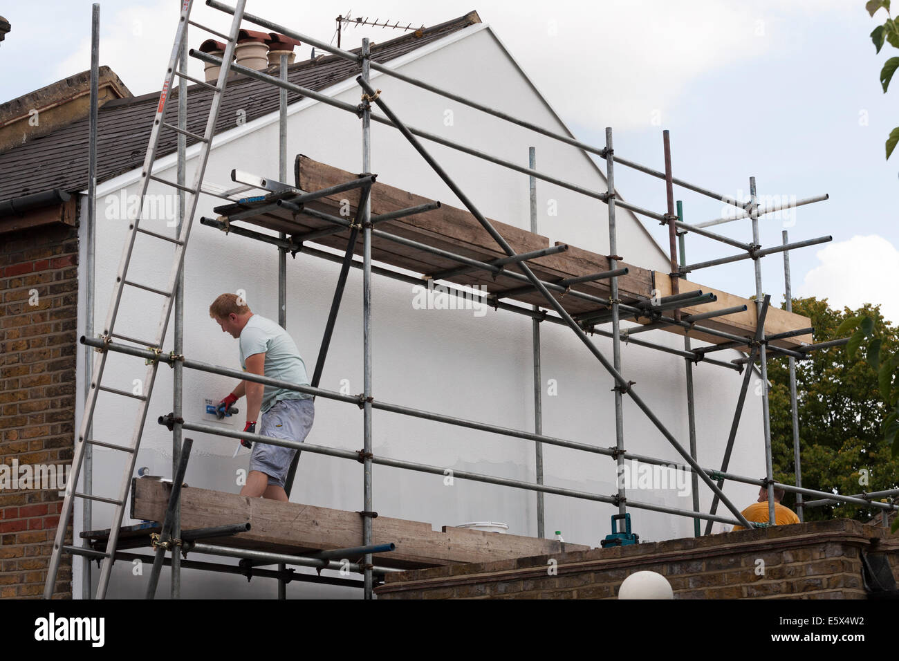 Builders apply / trowel / float final outer silicone coat to rigid foam ...