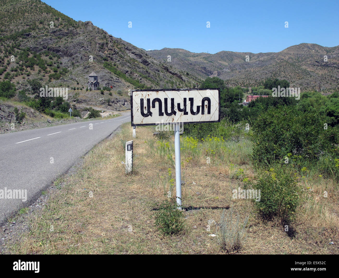 A road sign with Armenian letters indicates a village on the road ...