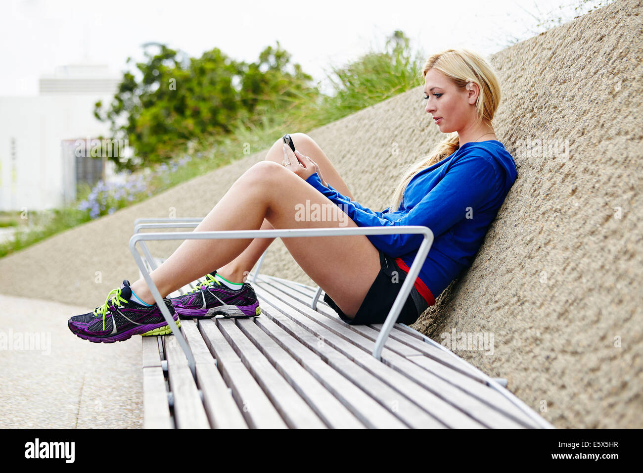 Woman sitting on bench using hi-res stock photography and images - Alamy