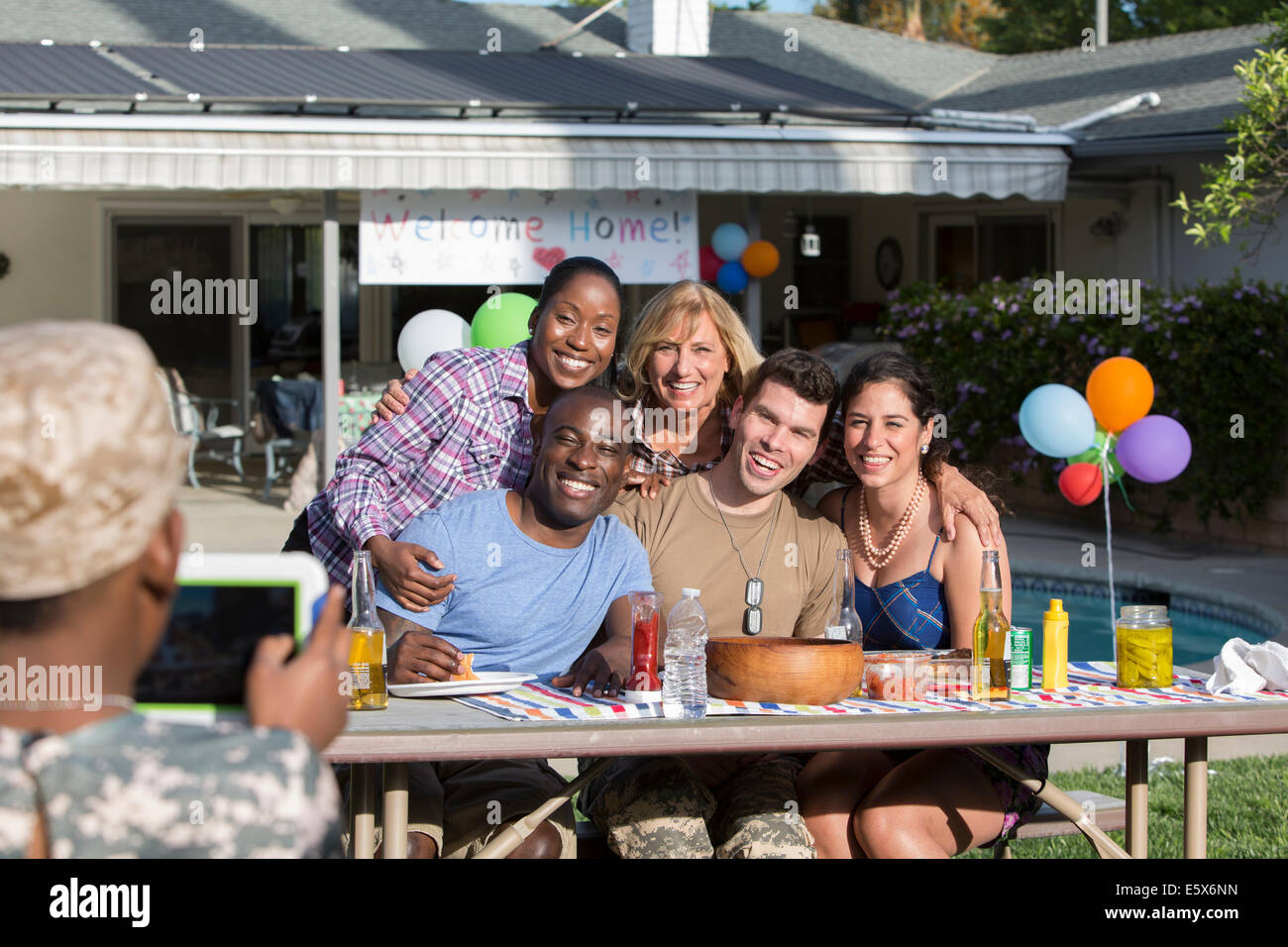 Boy photographing male soldier with family and friends at homecoming ...