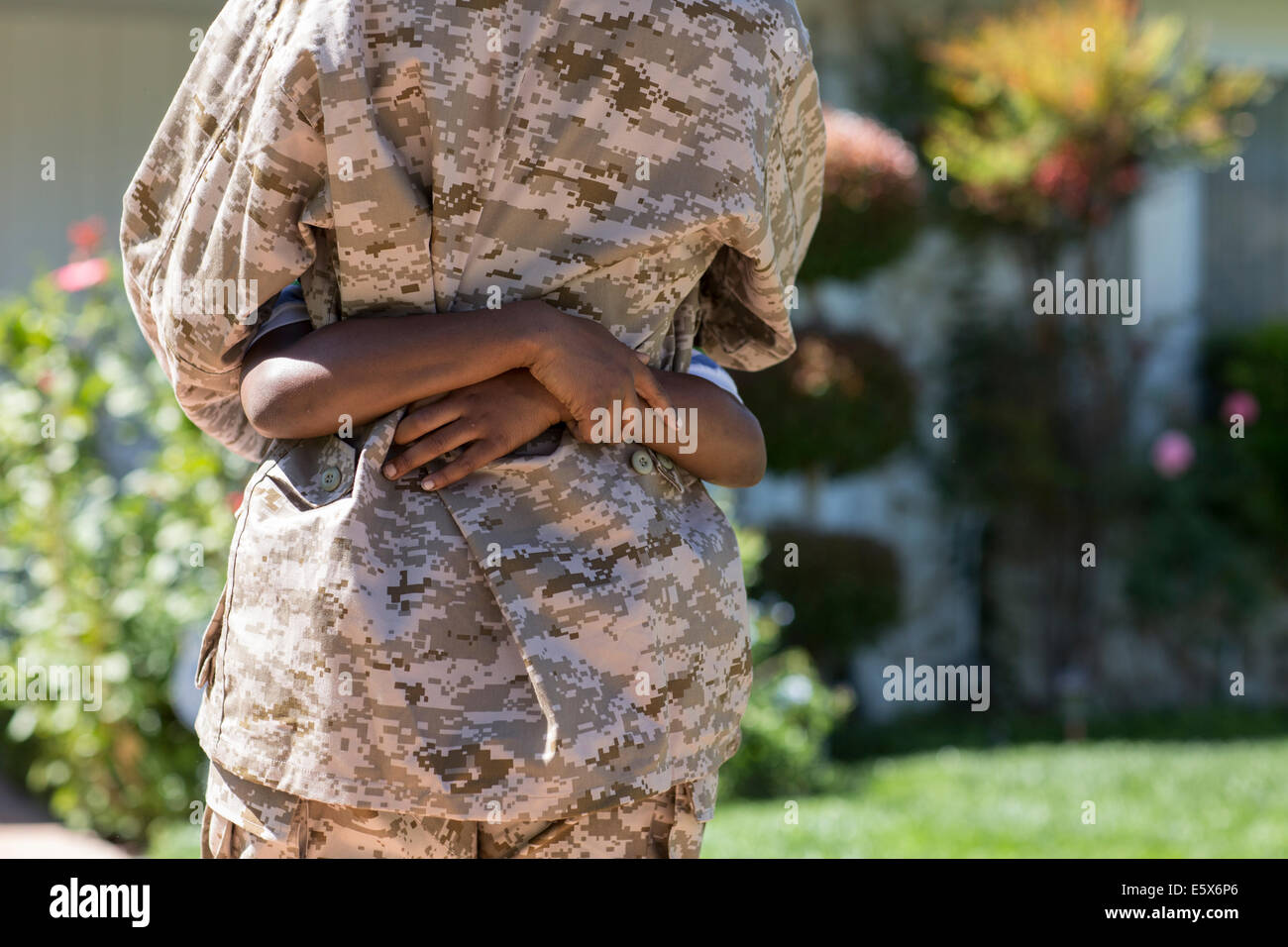 Cropped rear view of female soldier hugging son on homecoming Stock ...