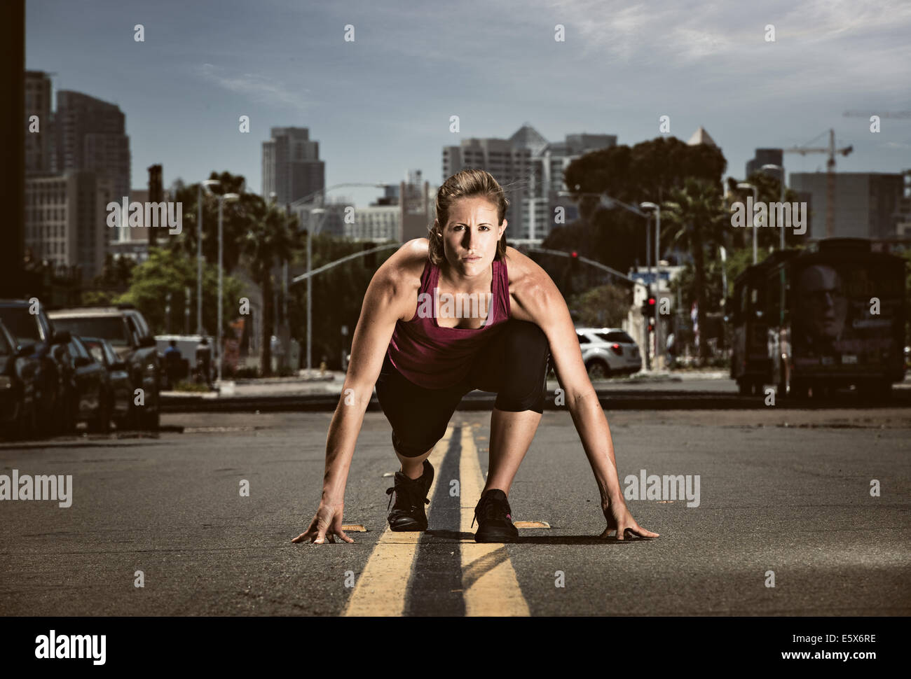 Young adult woman in start position in road hi-res stock photography ...