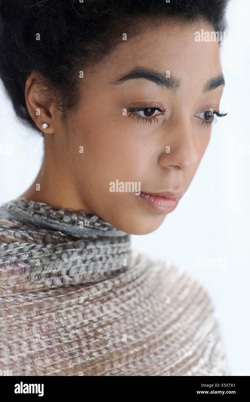 Cropped close up studio portrait of beautiful young woman gazing down ...