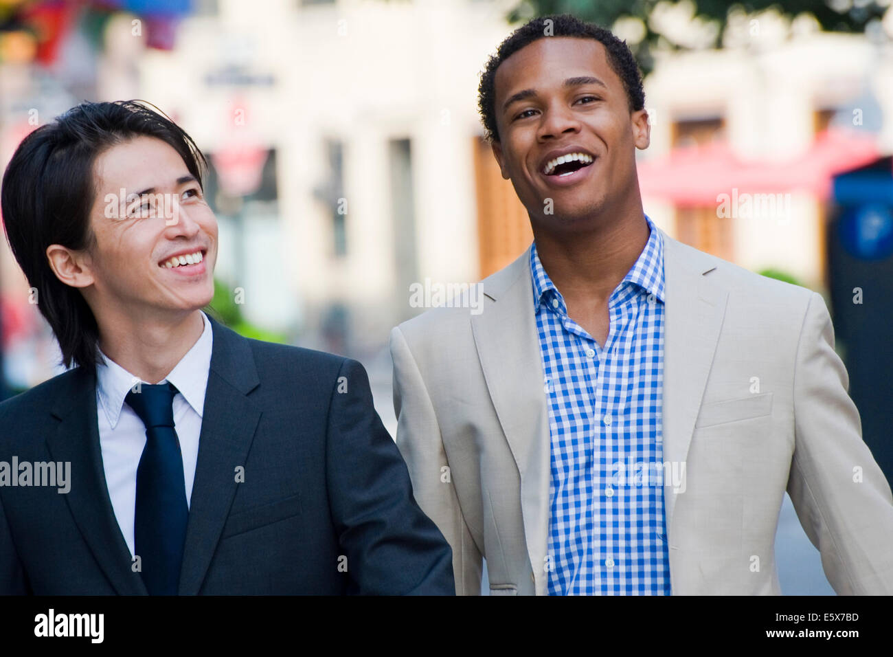 Two businessmen chatting and laughing on city street Stock Photo - Alamy