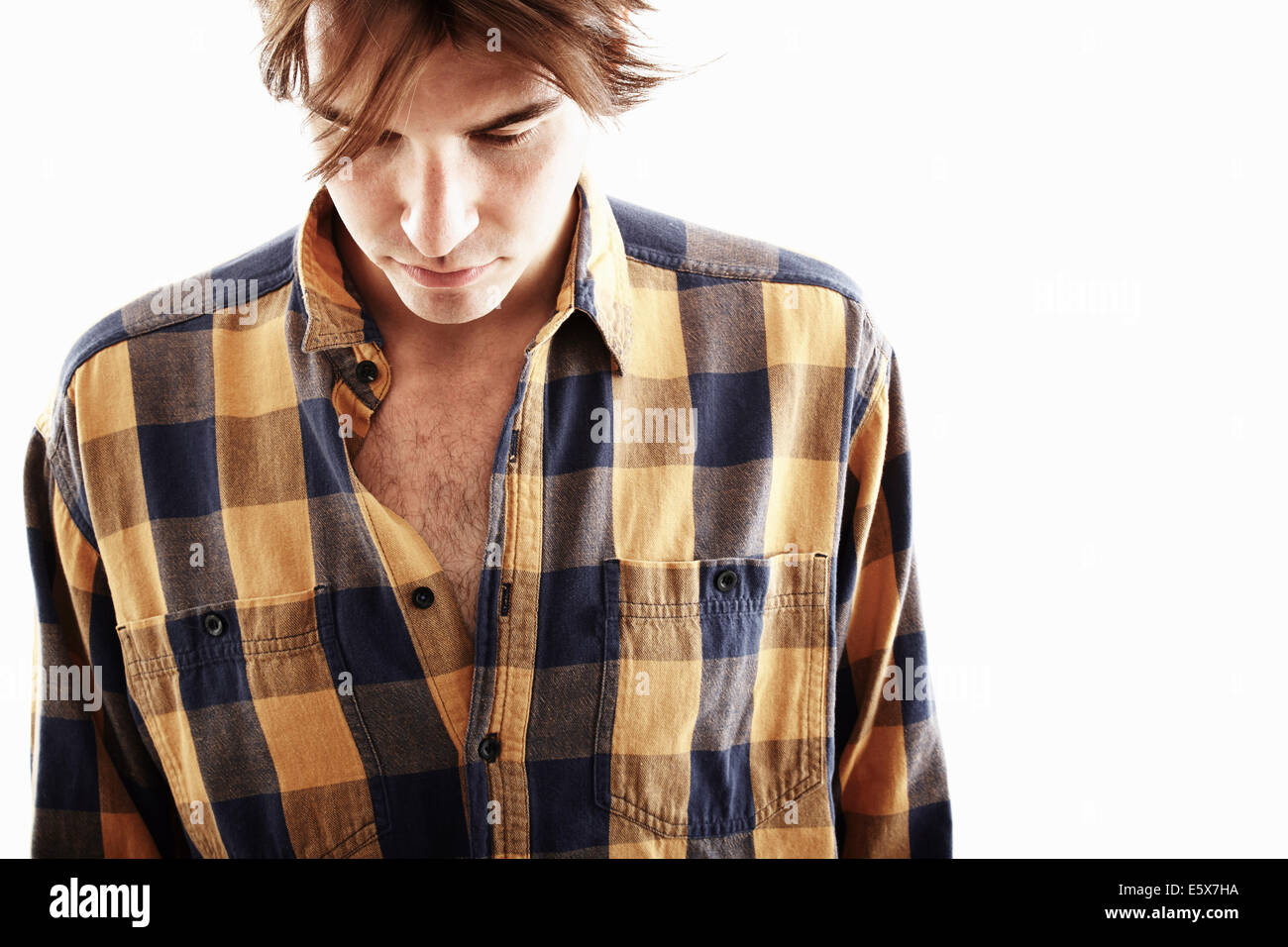 Studio portrait of young man looking down Stock Photo - Alamy
