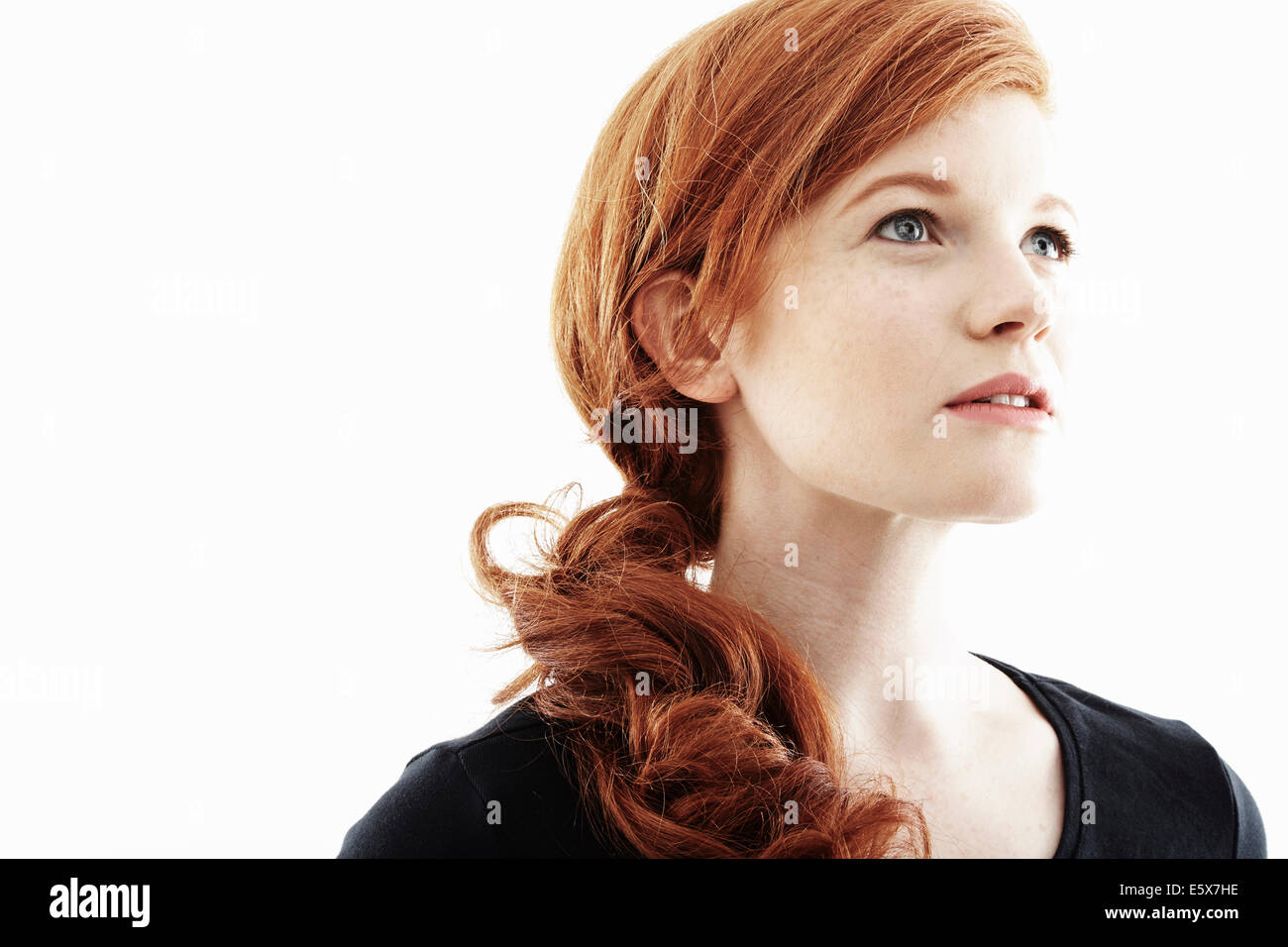 Studio portrait of young woman gazing upwards Stock Photo - Alamy