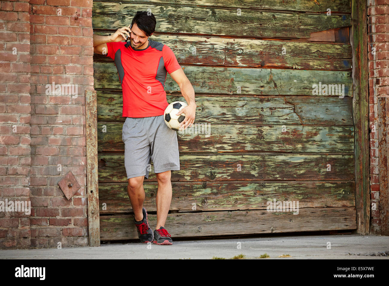 Young male soccer player chatting on smartphone Stock Photo - Alamy