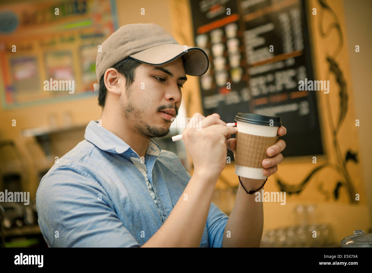 Barista writing on disposable cup in cafe Stock Photo - Alamy