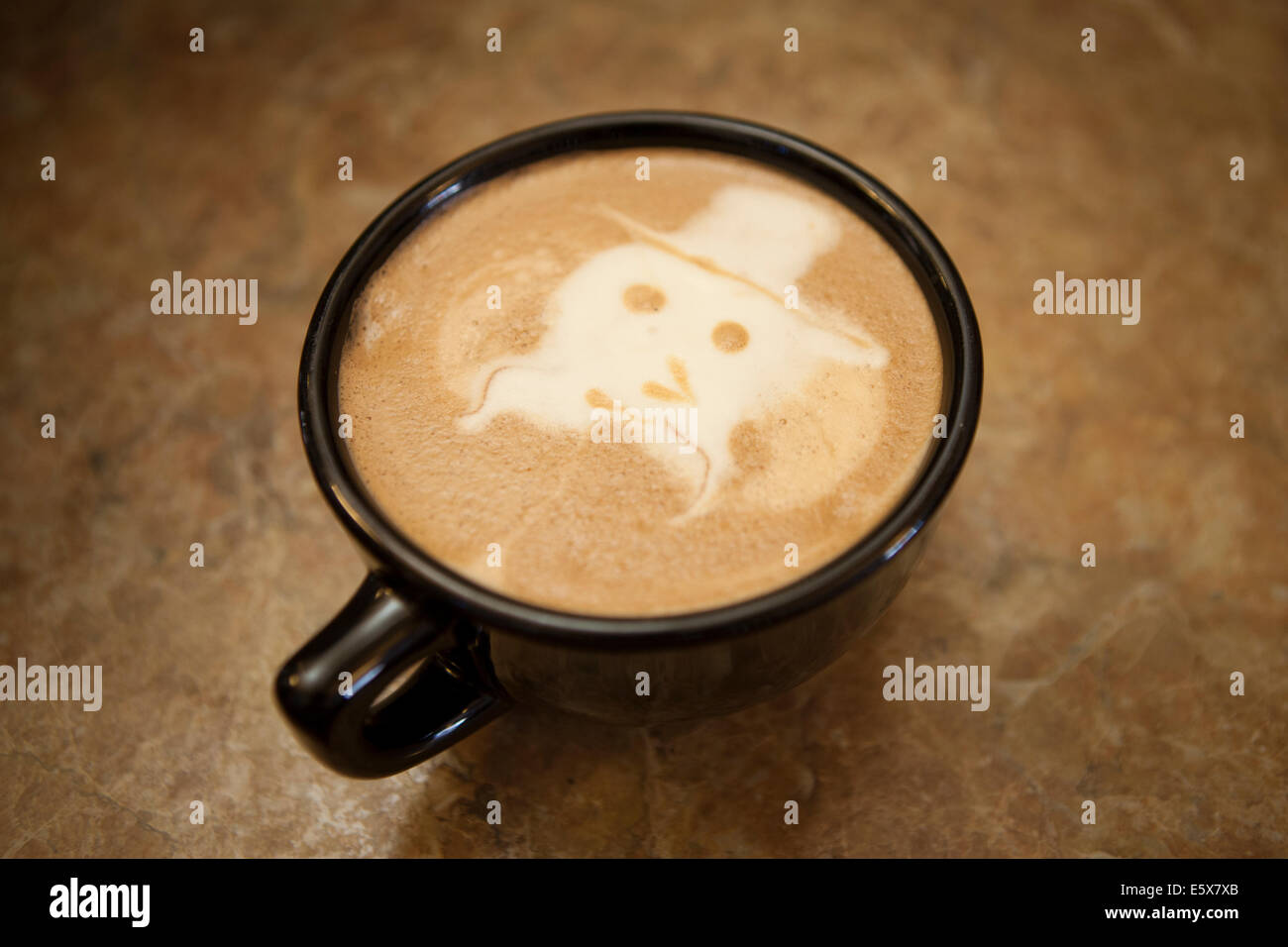 Close up of cup on cafe counter decorated with foam face Stock Photo ...