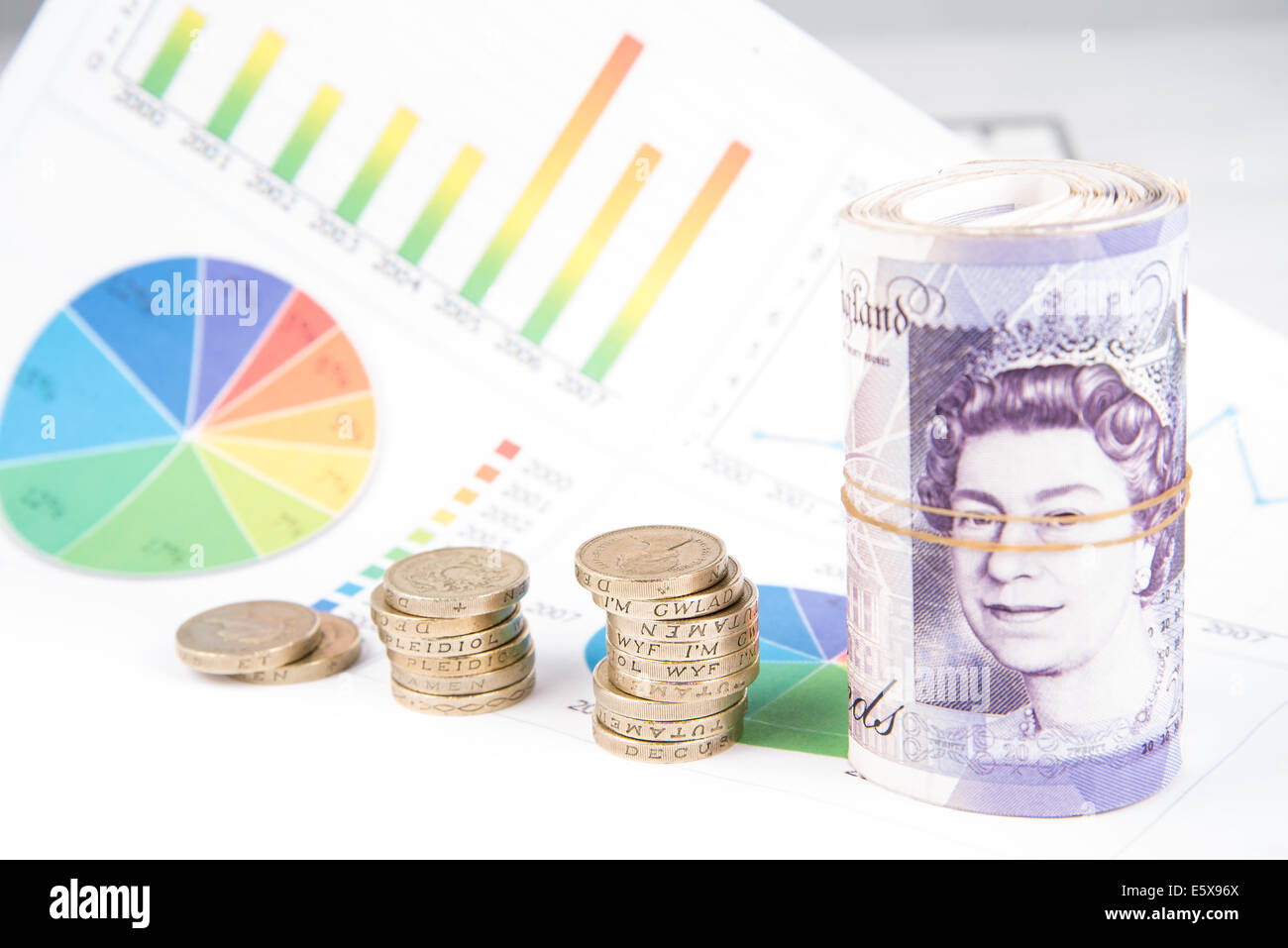 British pound coins and notes with financial chart Stock Photo - Alamy