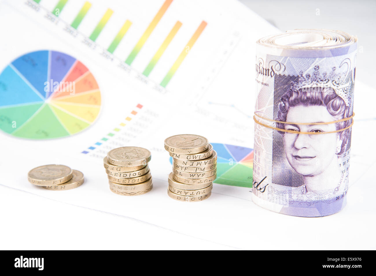 British pound coins and notes with financial chart Stock Photo - Alamy
