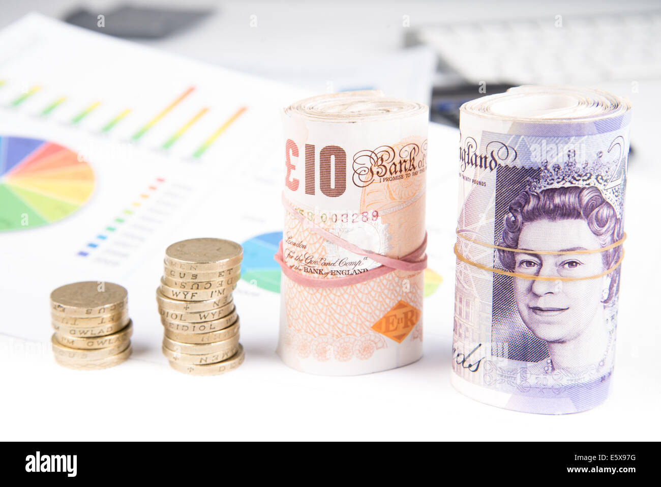 British pound coins and notes with financial chart Stock Photo - Alamy